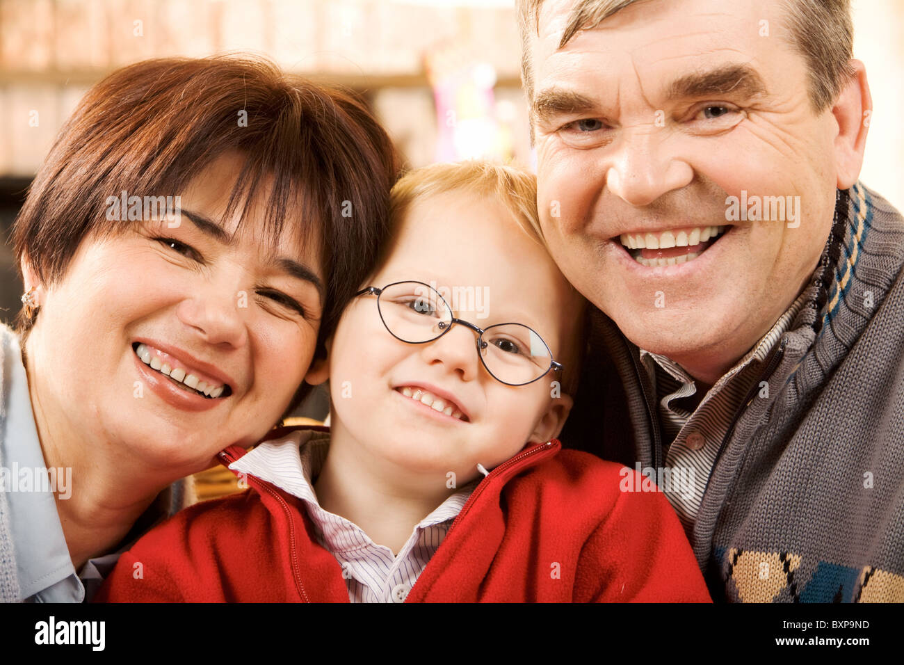 Portrait of happy grandparents and their grandson smiling at camera ...