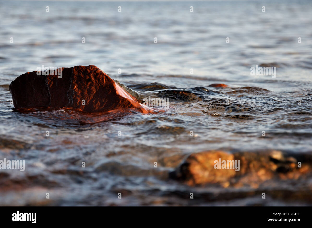 Small stones and rocks at the edge of the sea and in the waves Stock ...