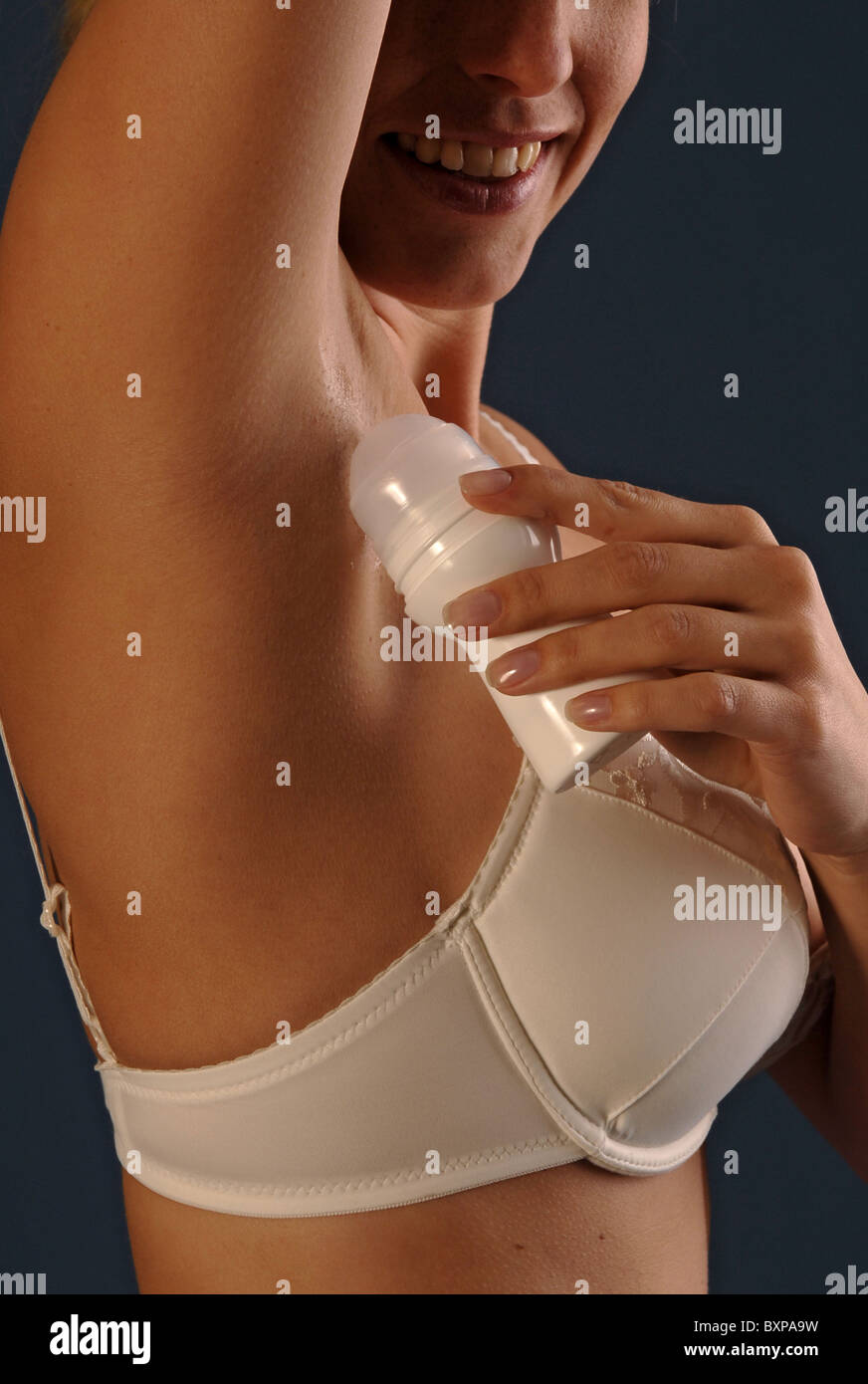 Young woman using deodorant Stock Photo - Alamy