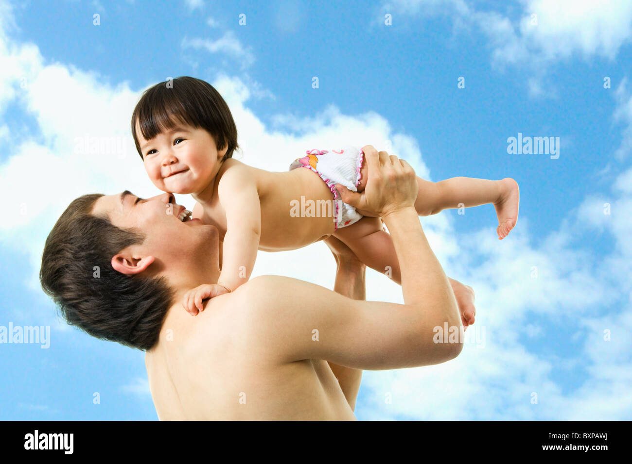 Portrait of father raising baby on the background of sky Stock Photo ...