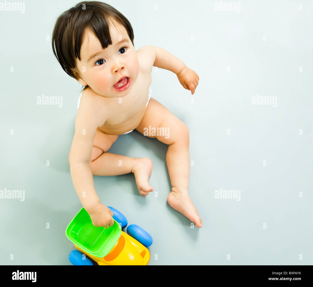 Image of little girl sitting and touching toy car Stock Photo - Alamy