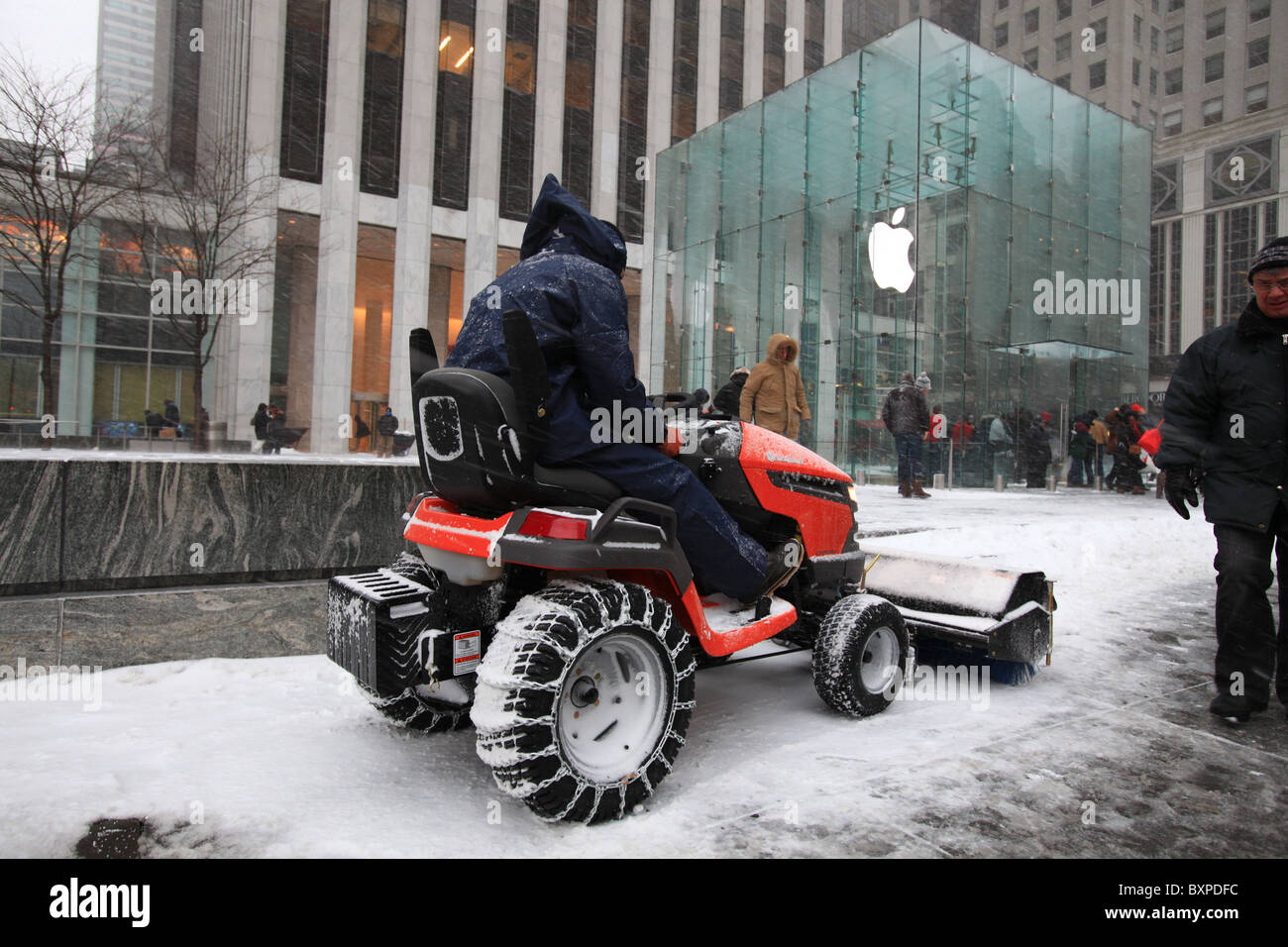 Snowplow clearing pavement on Fifth avenue outside Apple store, New ...
