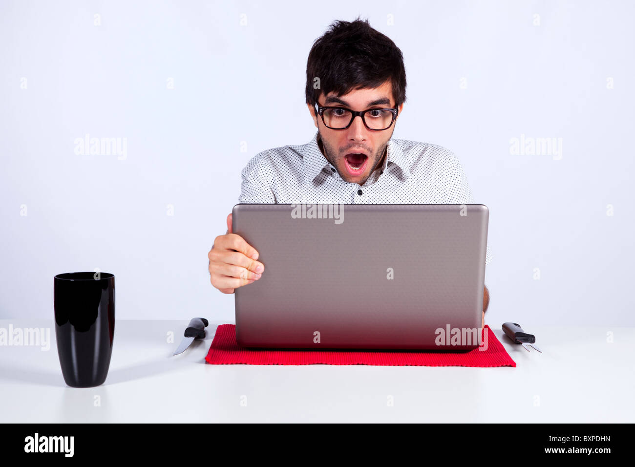 young man shocked with something he see on his laptop computer Stock ...