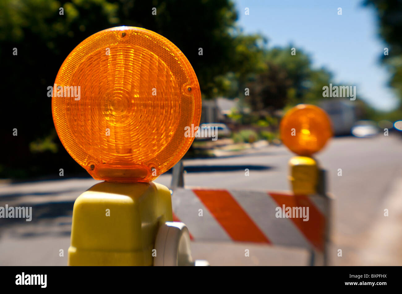 Orange caution lamps atop orange and white traffic barricades Stock ...