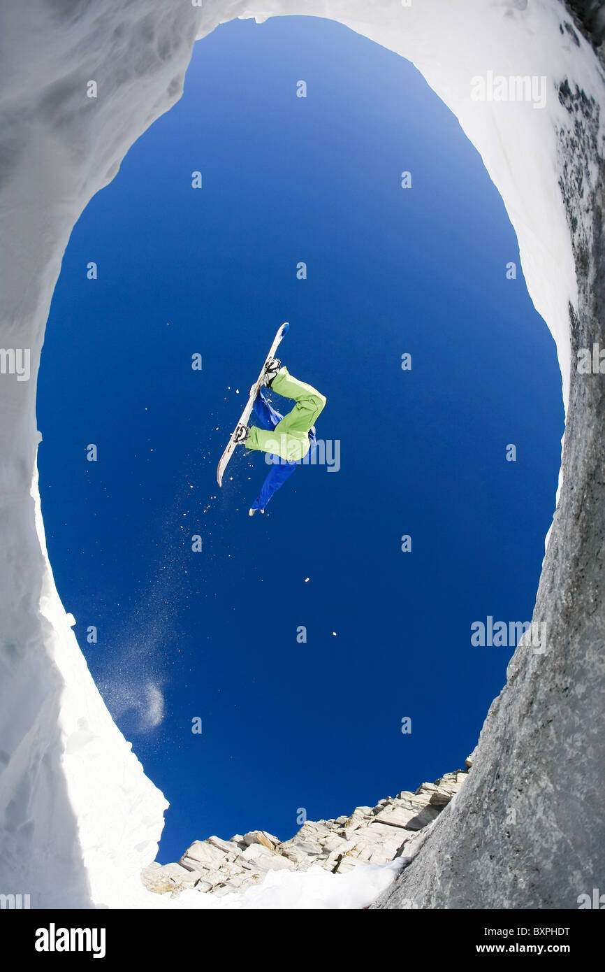 Below view of fearless sportsman jumping high over snow covered ...