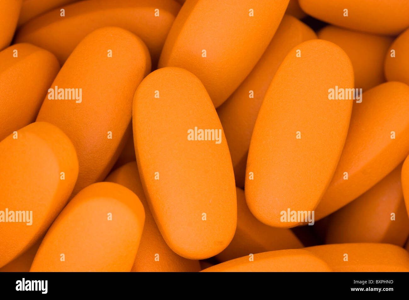 A group of orange multi vitamin tablets Stock Photo - Alamy