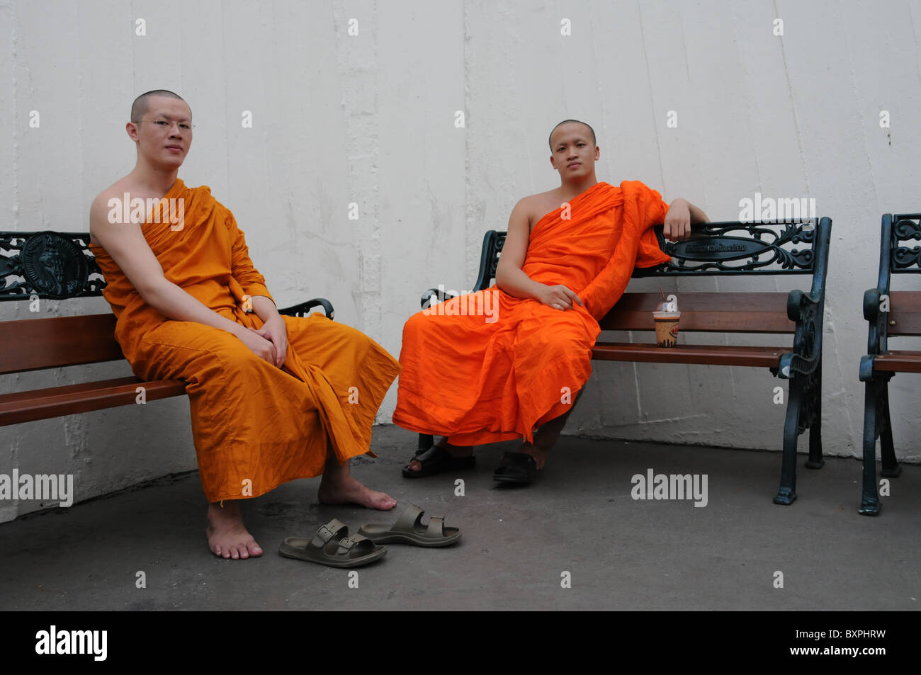 Two Young Monks sitting on a Bank at the Golden Mount Temple Stock ...