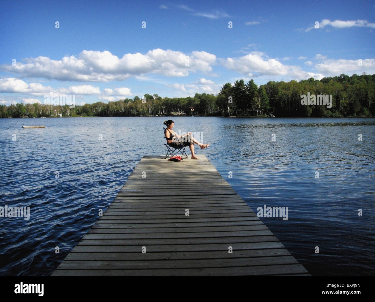 Woman reading book lake side hi-res stock photography and images - Alamy