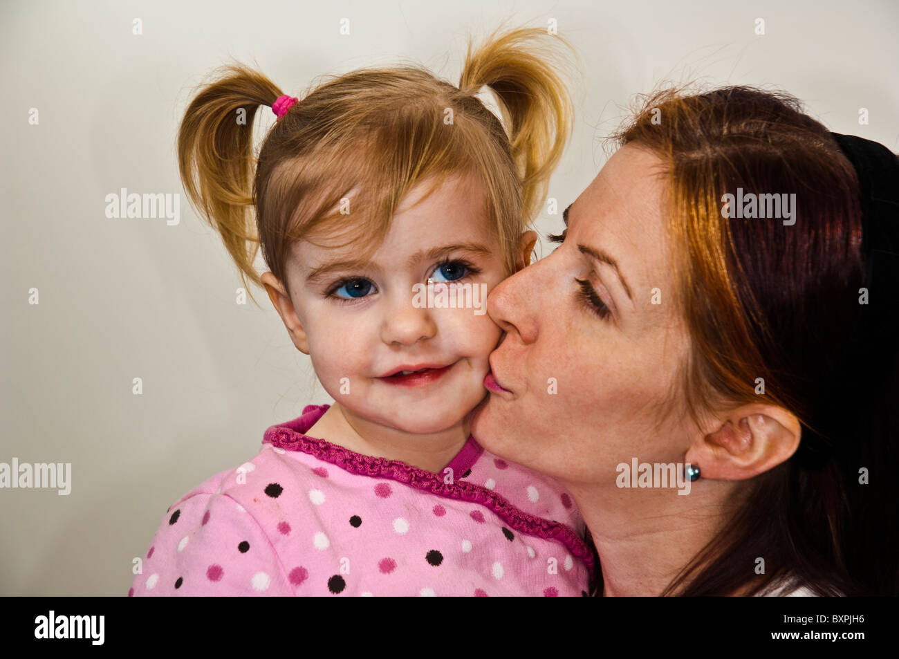 Mother embracing and kissing her daughter Stock Photo - Alamy