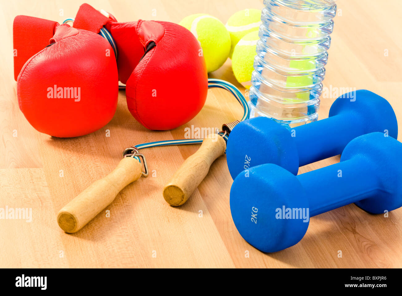 Photo of two blue barbells, some tennis balls, bottle of water and ...
