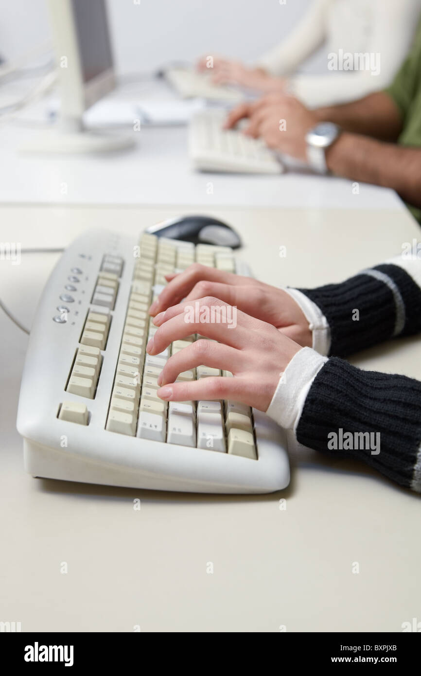 Closeup of caucasian female student typing on keyboard in computer lab ...