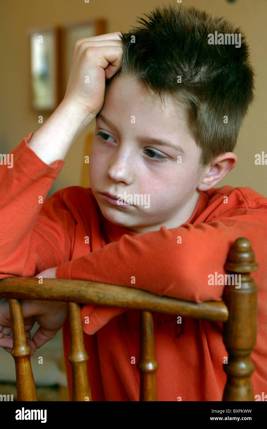 Sulky looking boy at home Stock Photo - Alamy