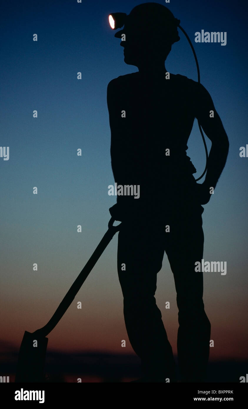 Silhouetted Miner With Lit Hat And Shovel Stock Photo - Alamy