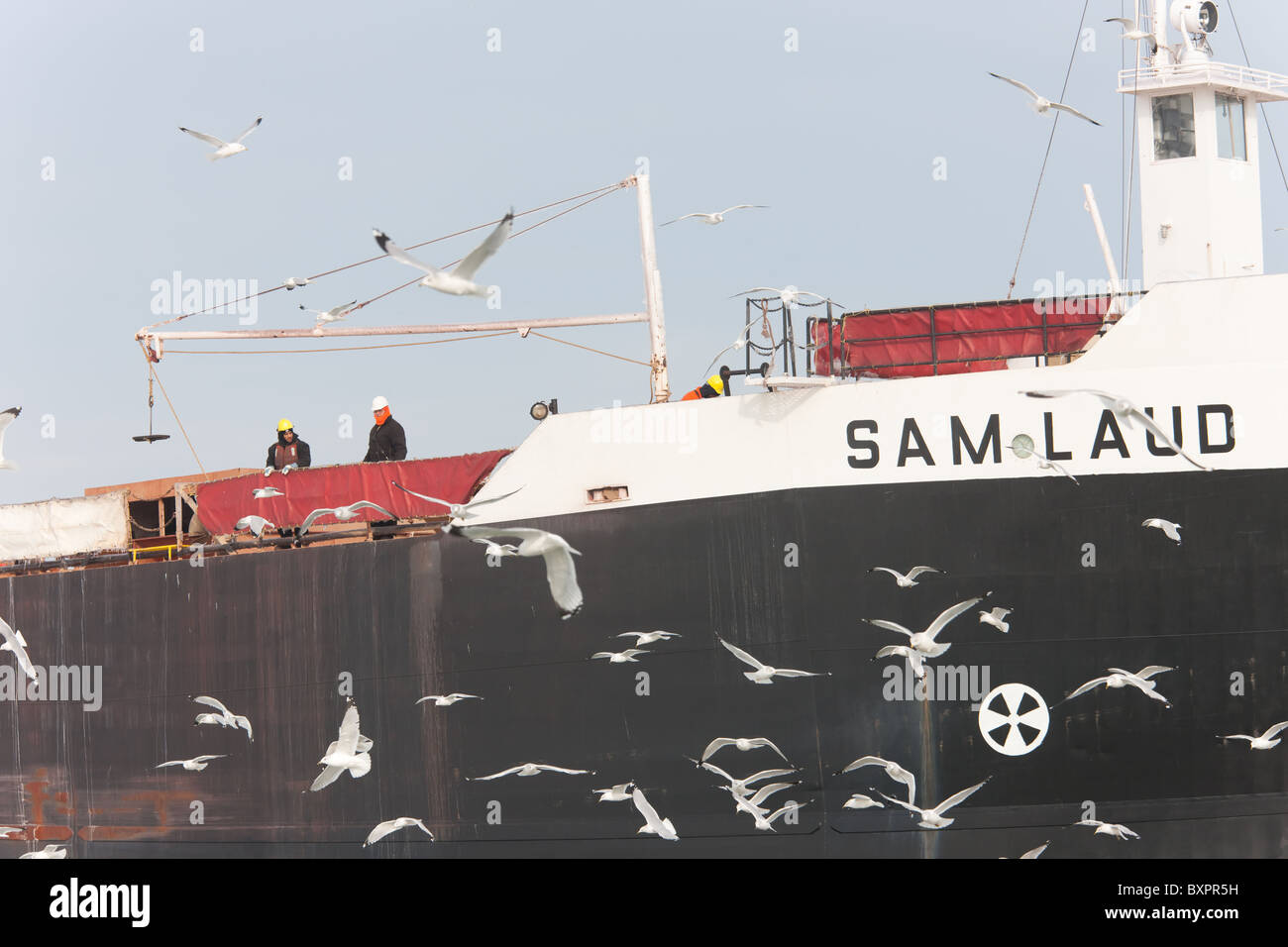 Crew members stand on the deck of the cargo ship M/V Sam Laud in winter ...