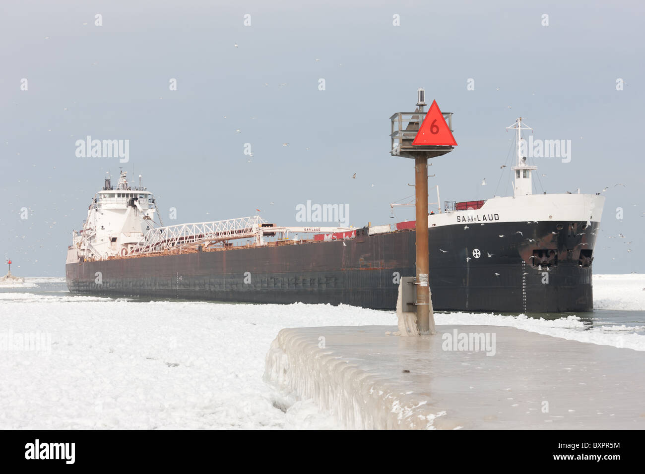 Cargo ship M/V Sam Laud passes a channel marker on Lake Erie in winter ...