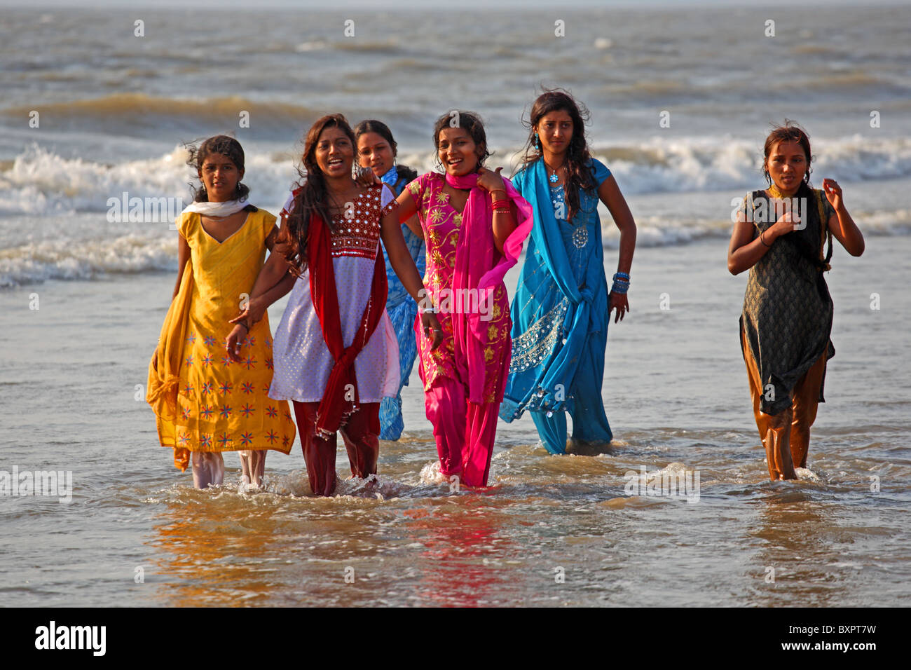 Young Indian women walking along Juhu Beach at sunset in Mumbai, India ...