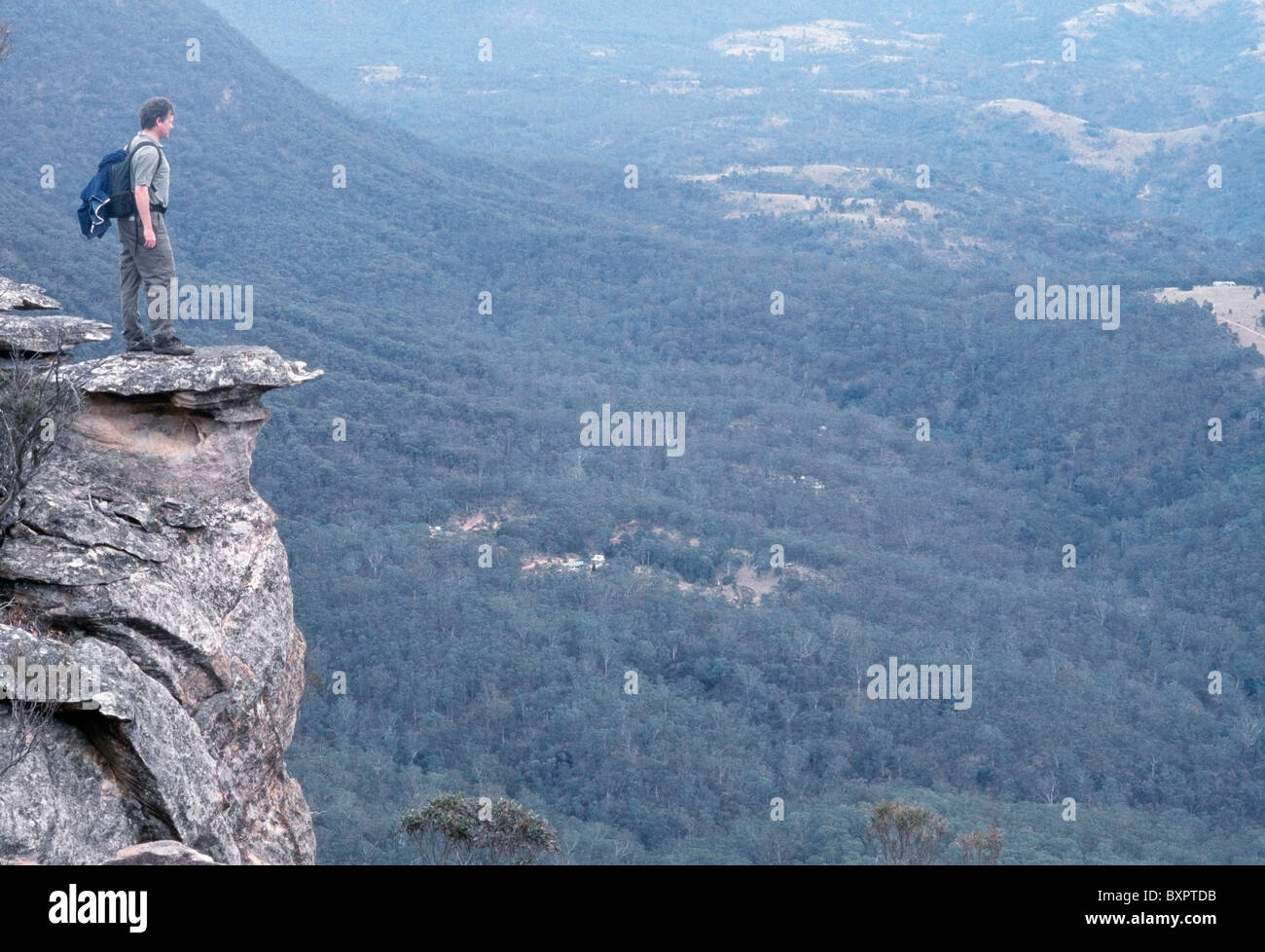 Bushwalker in Southern highlands on rock overlooking valley; New South ...