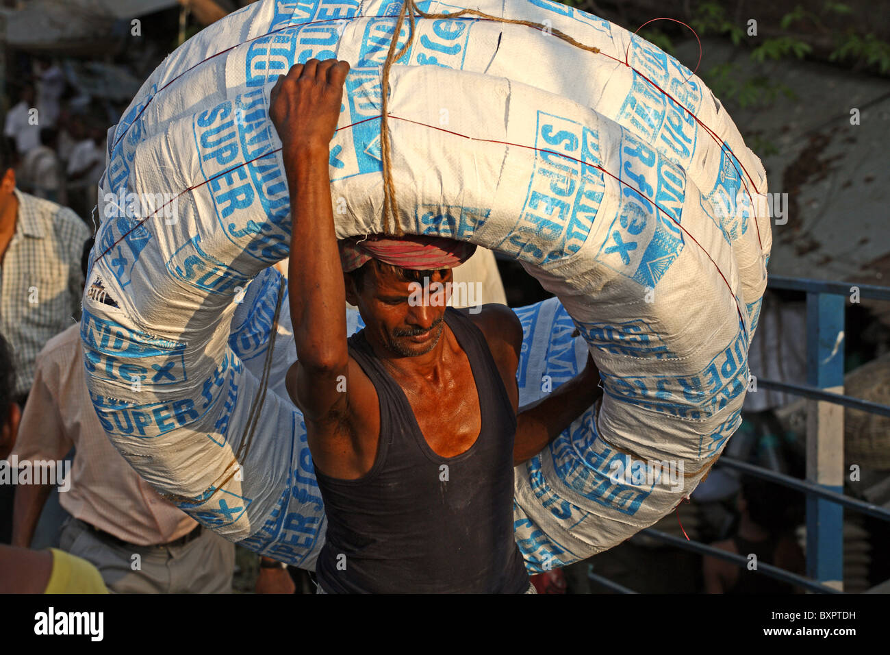 Man carrying large weight on head in Calcutta, India Stock Photo - Alamy