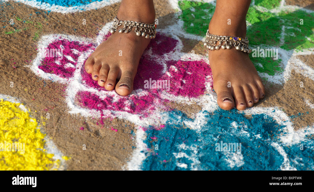 Indian childs bare feet standing on a Rangoli coloured powder ...