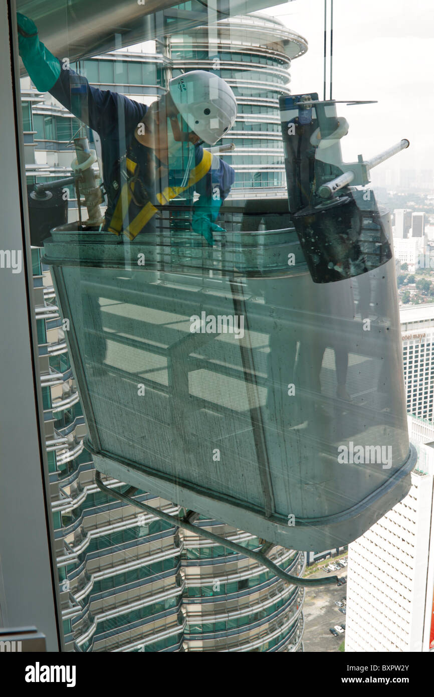 A worker washes the windows at the 47th floor of the Petronas Twin ...