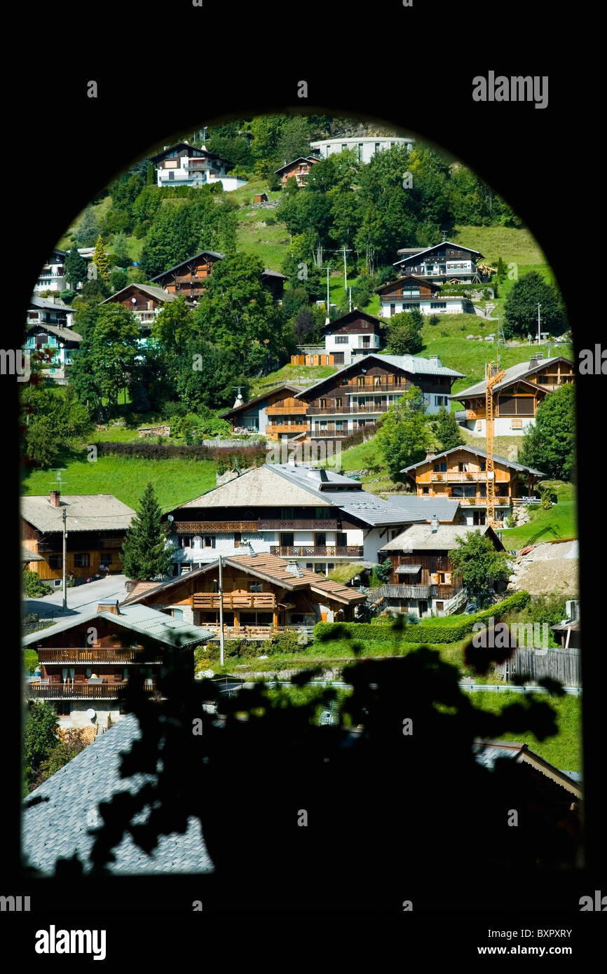 View Through Arched Window Of Alpine Lodges And Chalets On Hillside ...