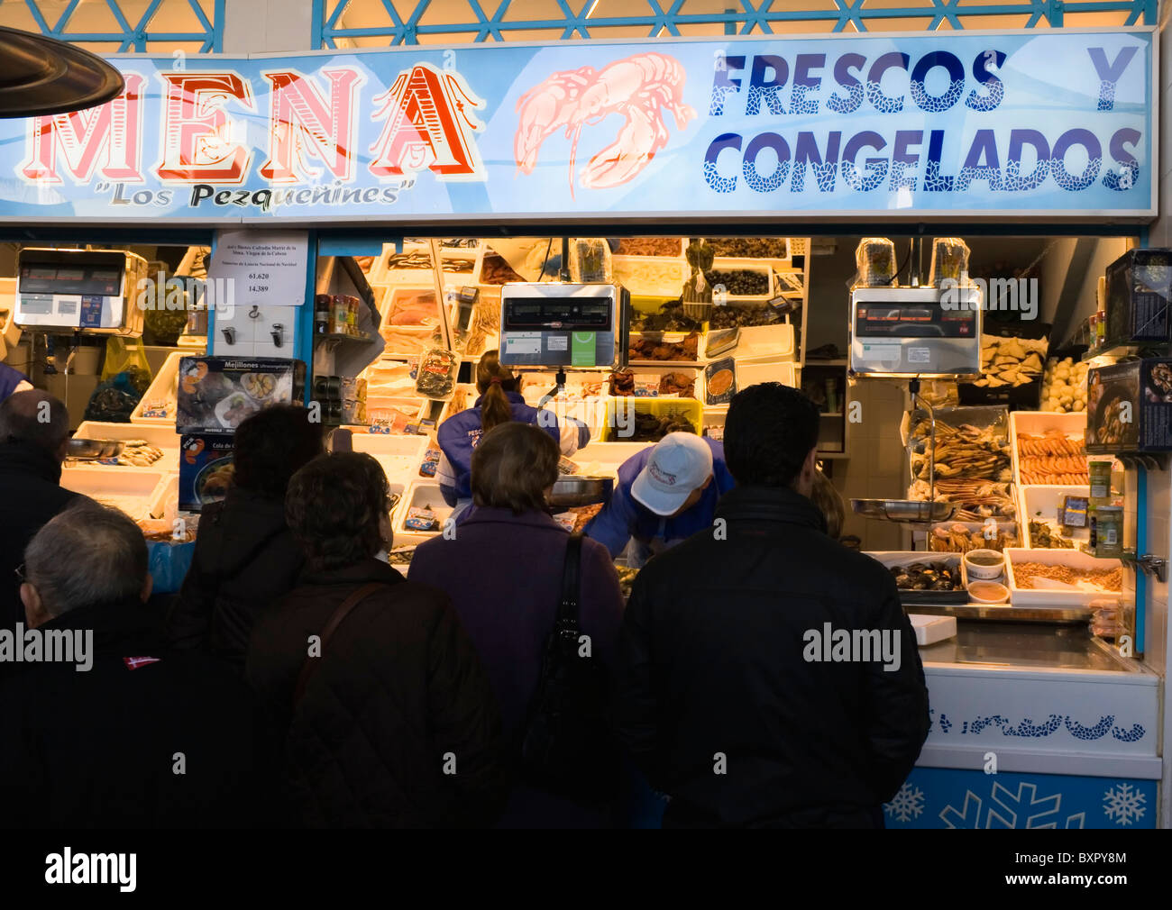 Customers buying fish off a fishmonger in the central market, Andujar ...