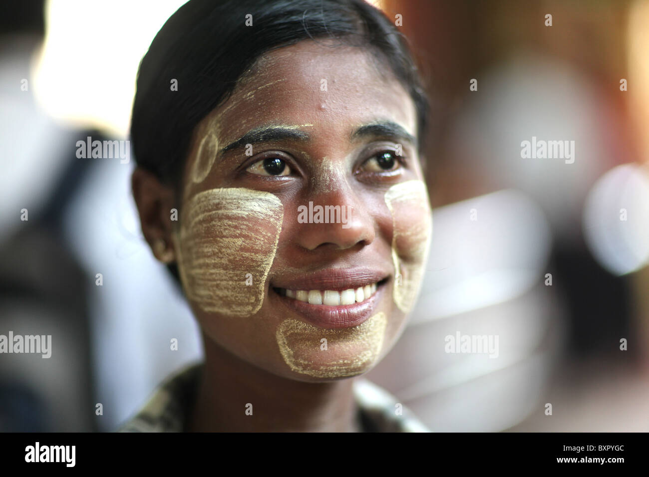A local woman smiles while wearing Myanmar makeup in Bago, Myanmar ...