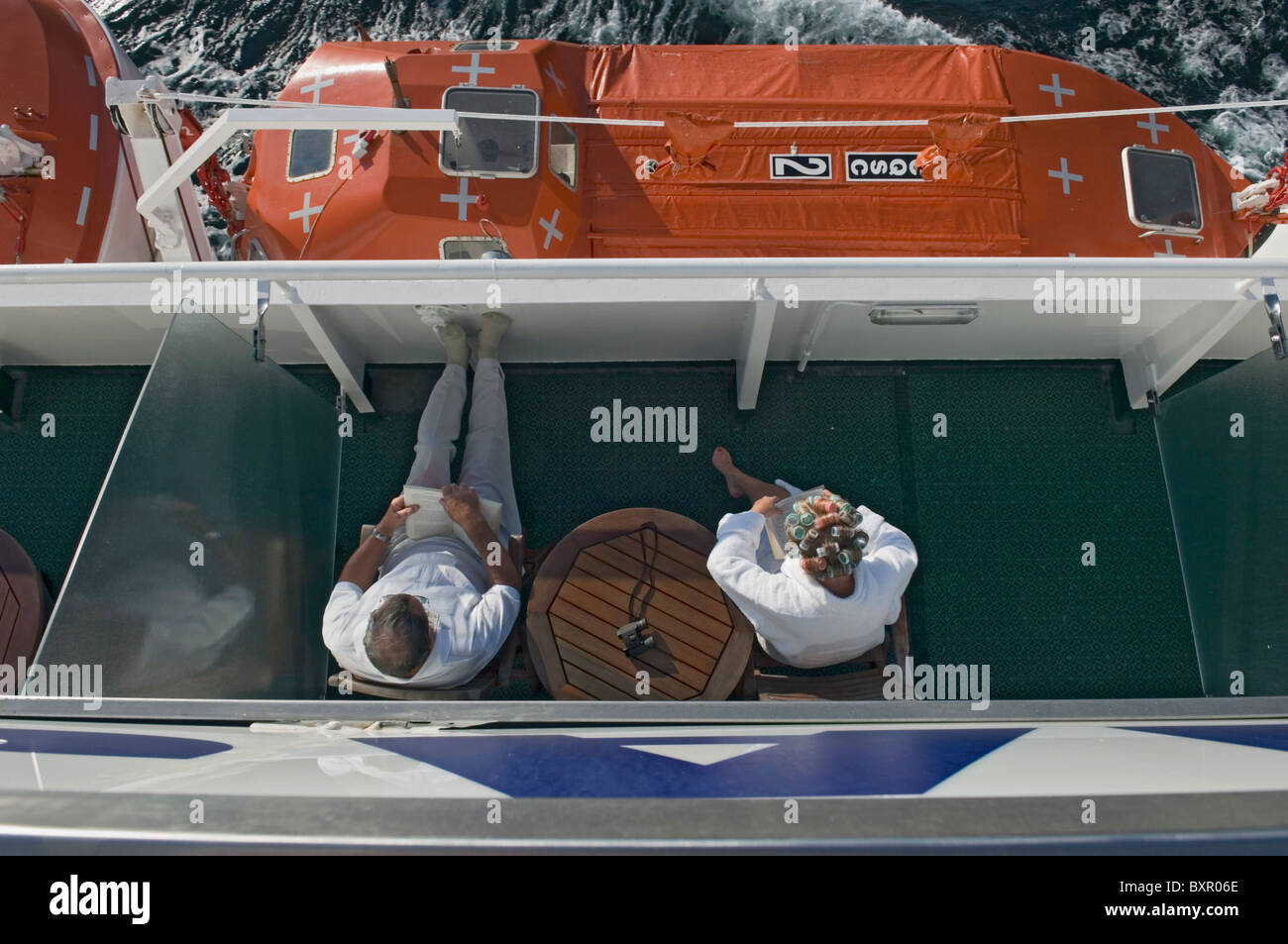A Husband And Wife Reading And Enjoying The Sea View From Their Balcony ...