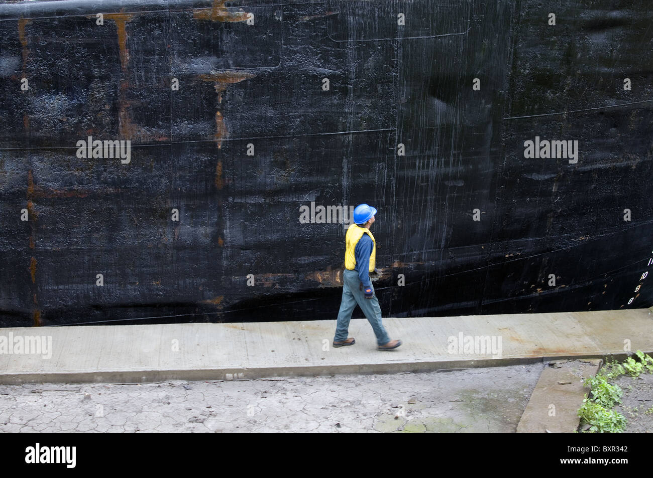 Man walking along cargo ship carrying salt going through lock Stock ...