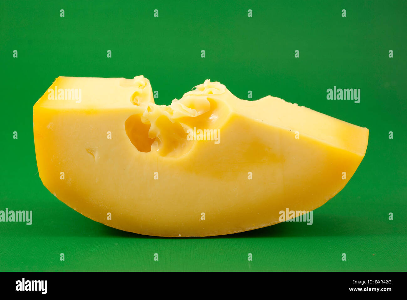 Gruyere cheese isolated on green background Stock Photo - Alamy