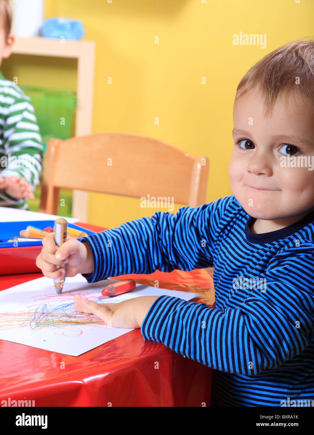 Cute caucasian toddler drawing a picture in kindergarten Stock Photo ...
