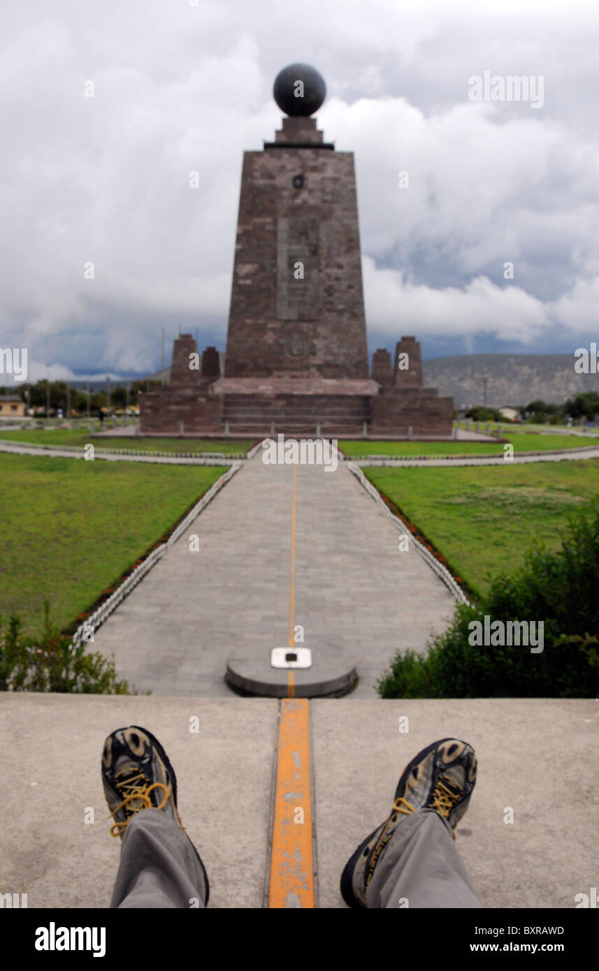 A traveller with one feet each across the Equator line marked on the ...