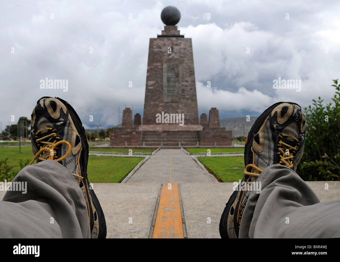 A traveller with one feet each across the Equator line marked on the ...