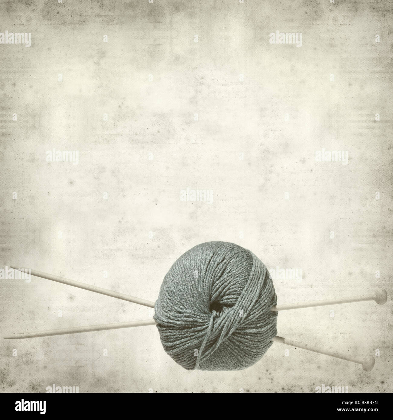 textured old paper background with pair of knitting needles and ball of ...