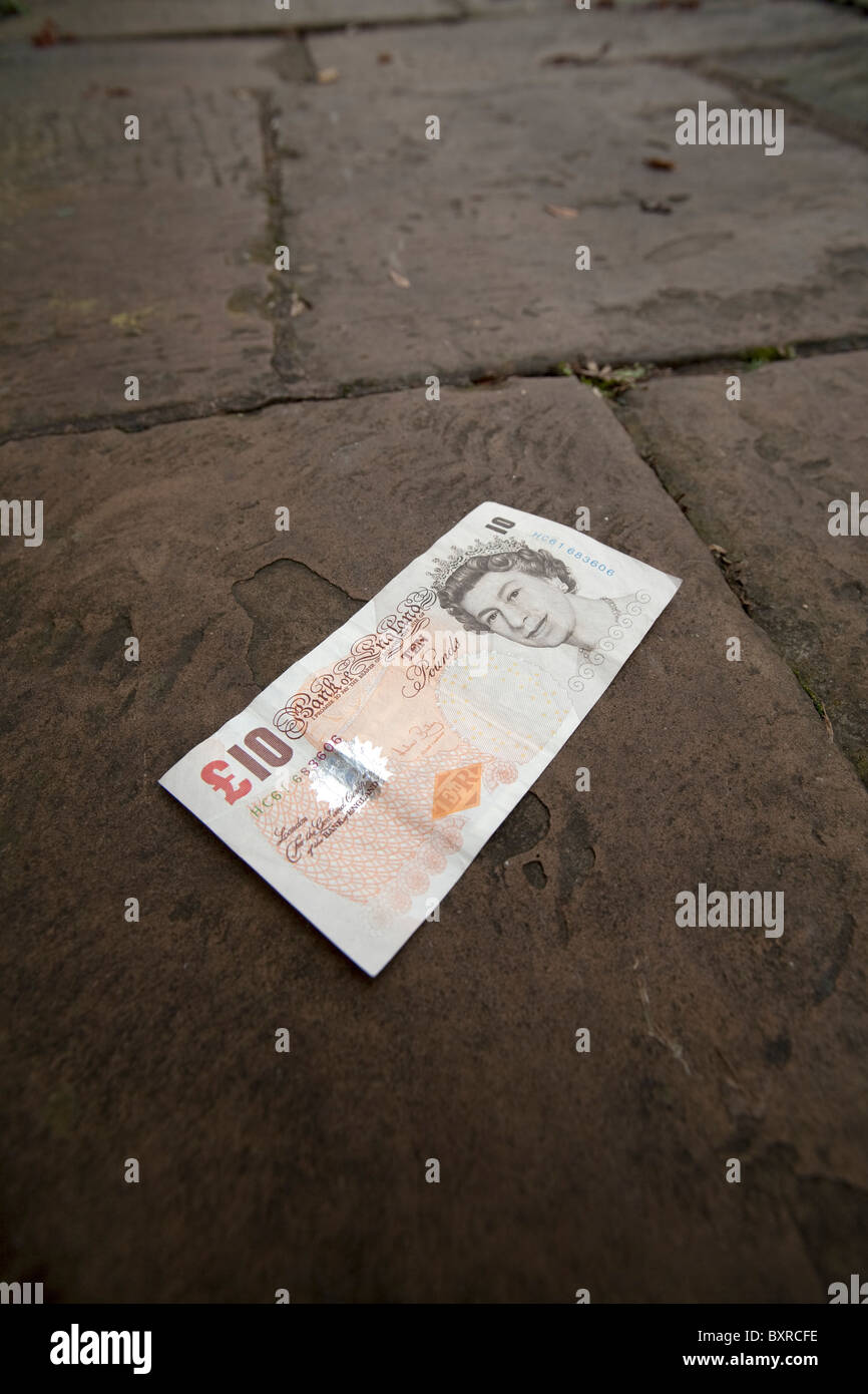 10 ten pound sterling bank note on pavement sidewalk Stock Photo - Alamy
