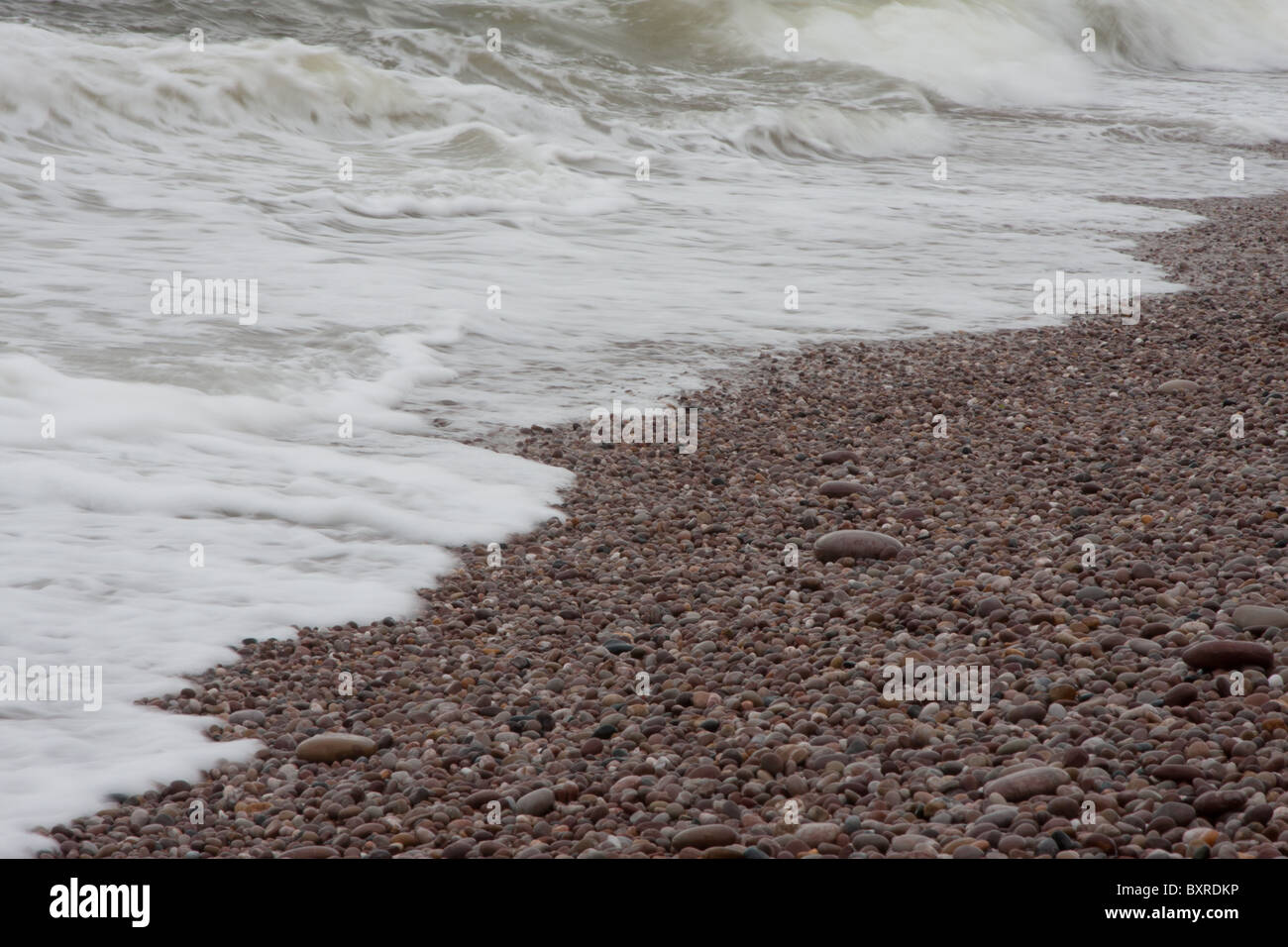 Waves breaking on a pebble beach Stock Photo - Alamy