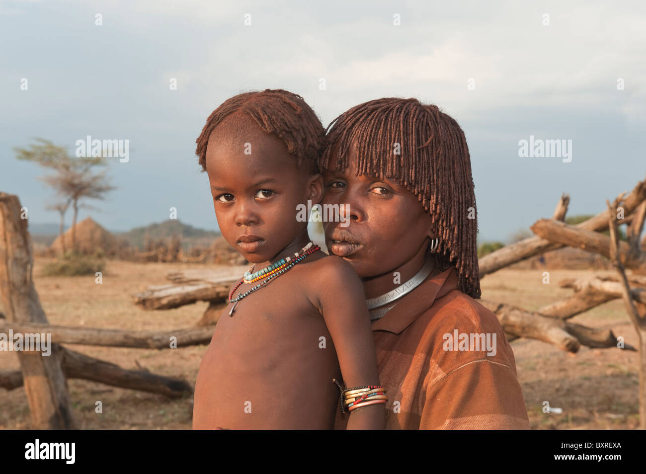 Young Hamar woman with red clay in the hair and her child, Omo river ...