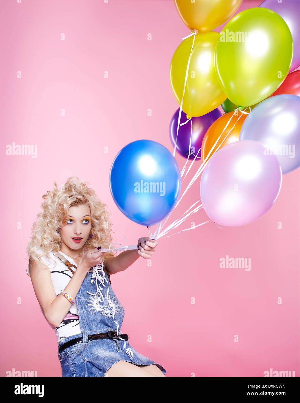 portrait of beautiful party blonde girl pulling balloons celebrating ...