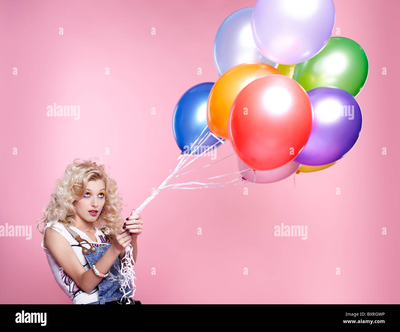 portrait of beautiful party blonde girl pulling balloons celebrating ...