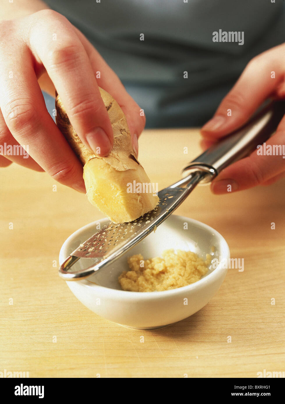 Female hand grating ginger rhizome into fine pulp with grater Stock ...
