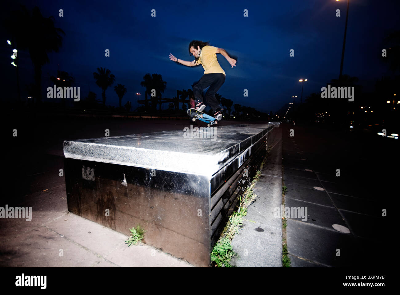 young men skating and doing tricks, sliding along an edge at barcelona ...