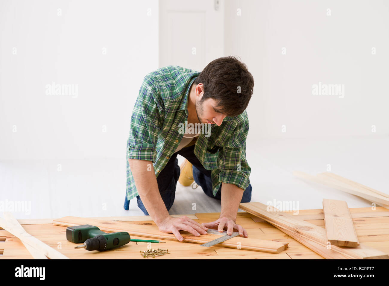 Home improvement - handyman installing wooden floor Stock Photo - Alamy