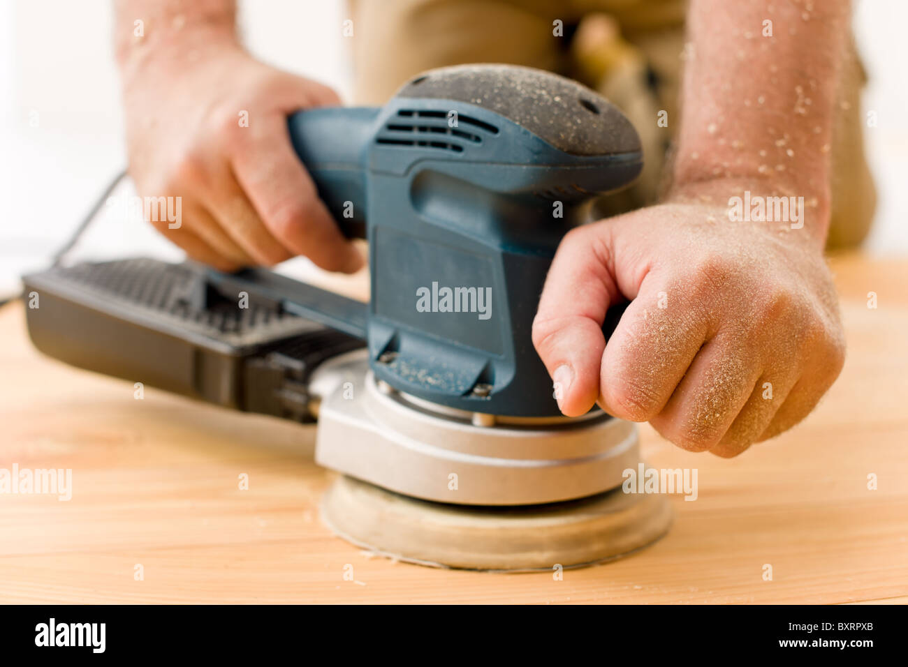 Home improvement - handyman sanding wooden floor in workshop Stock ...