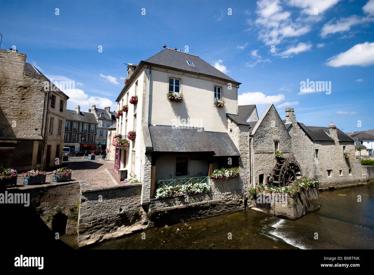 France, Normandie, Bayeux, Old watermill and buildings beside river ...