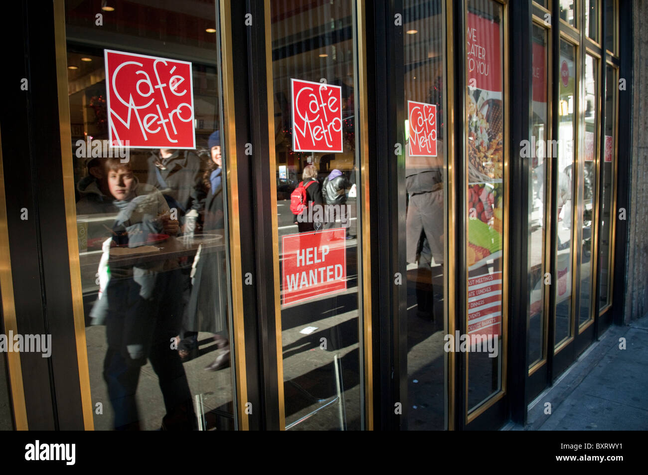 A Help Wanted sign posted in the window of a restaurant in midtown in ...