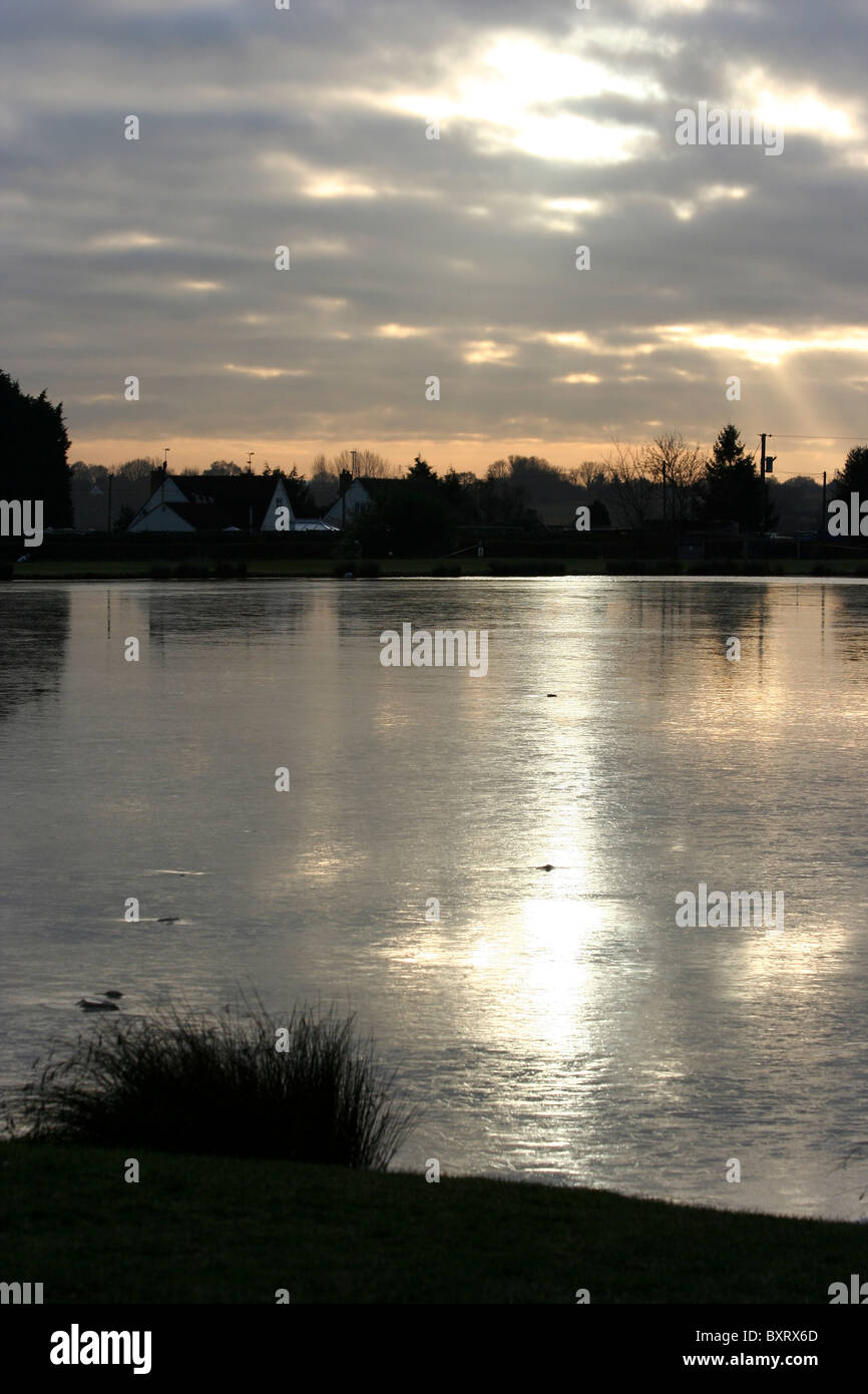 Winter evening light on an icy lake at Top Barn activity centre in ...