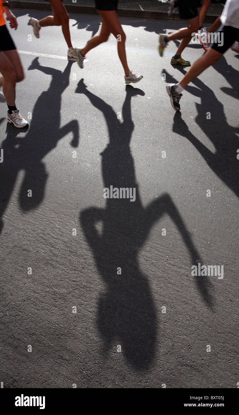 Marathon runners casting shadows Stock Photo - Alamy