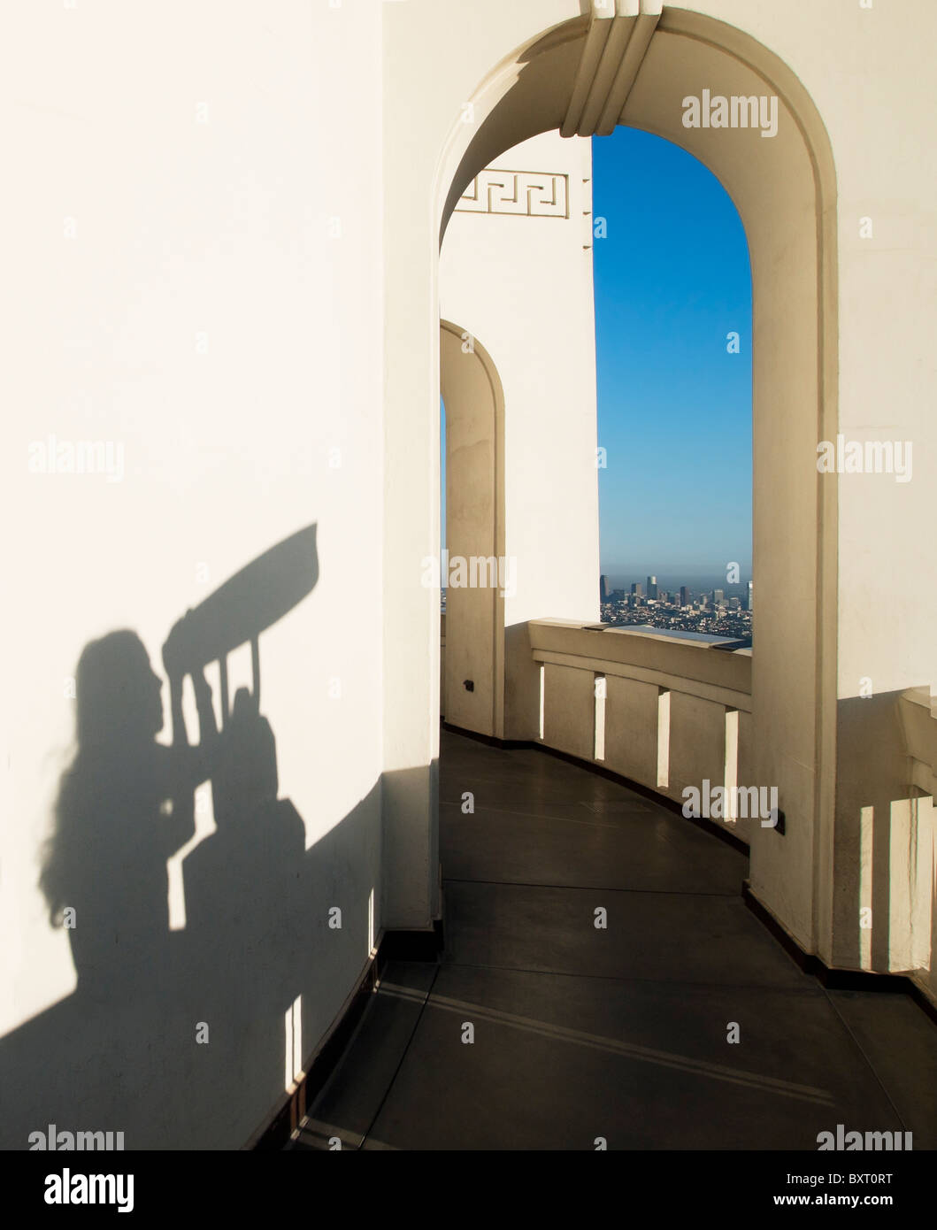 Silhouette of a woman looking through a telescope at Griffith ...