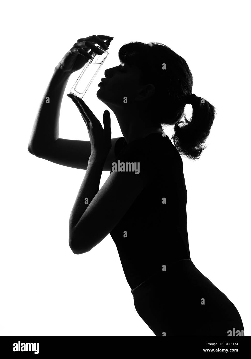 silhouette in shadow of a young woman kissing her perfume bottle in ...