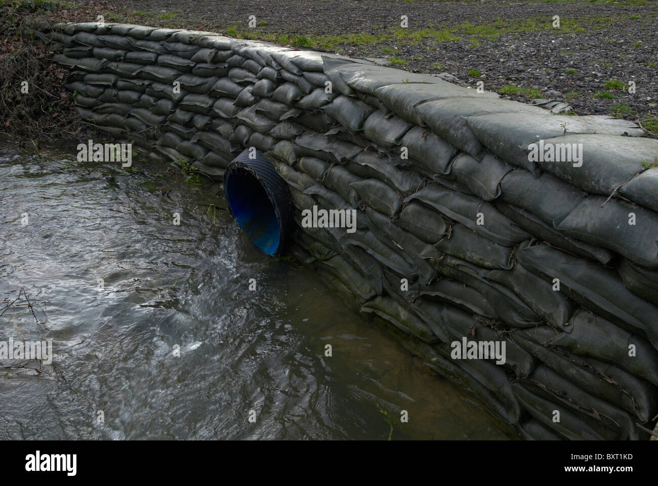 Pipe draining water into river Stock Photo - Alamy